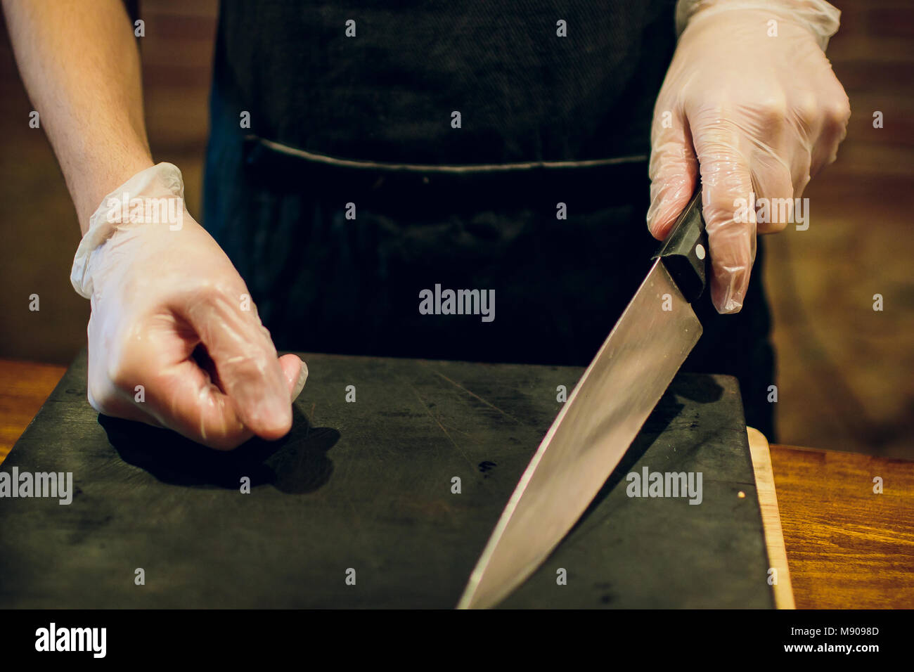 Male chef hands with knife. Cropped image of chef holding knife on ...