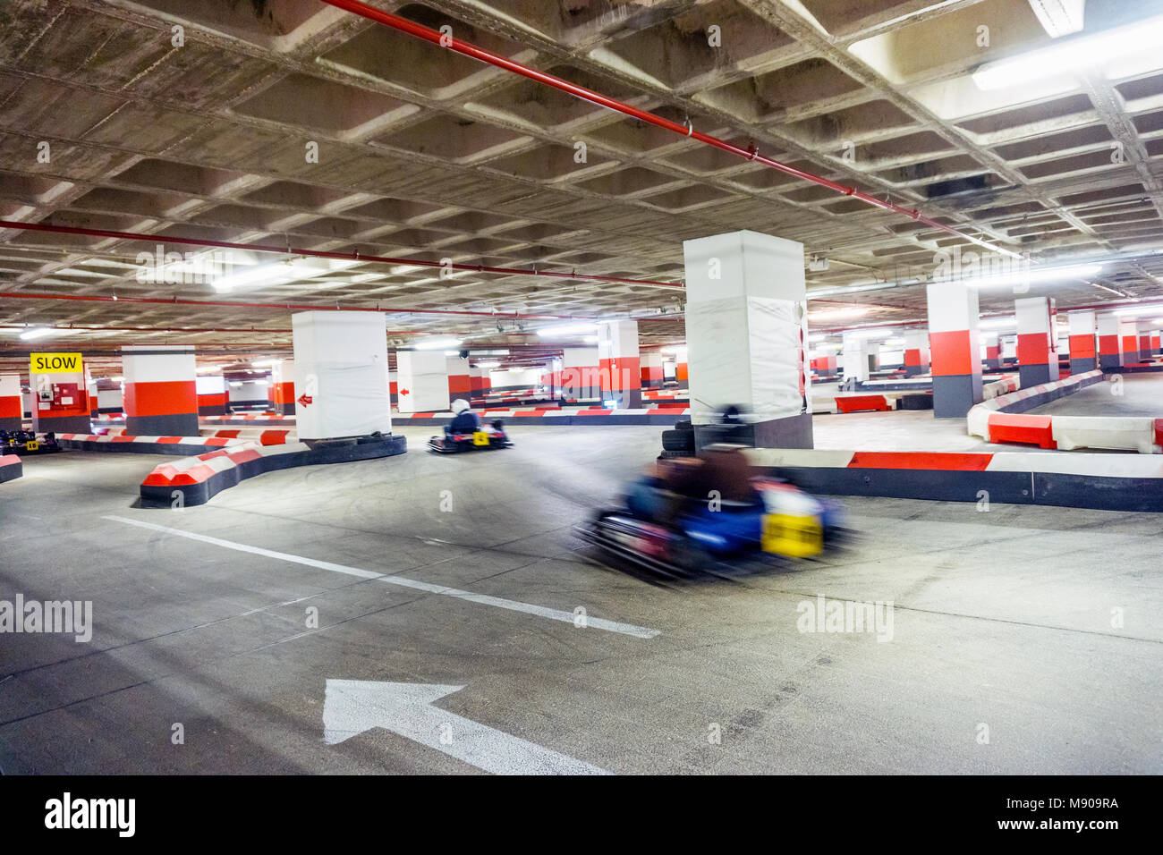 Two people racing on indoor karting track located in underground ...
