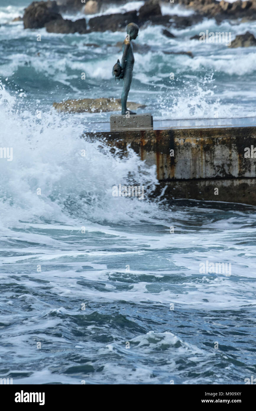 Wild mediterranean sea in Paphos harbour with statue of boy with fish ...
