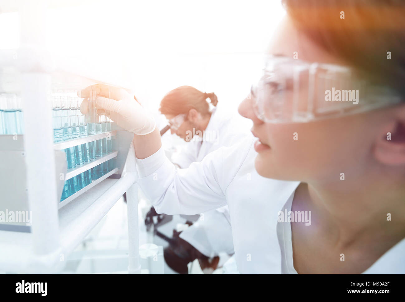 attractive young student scientist observing the blue indicator color ...