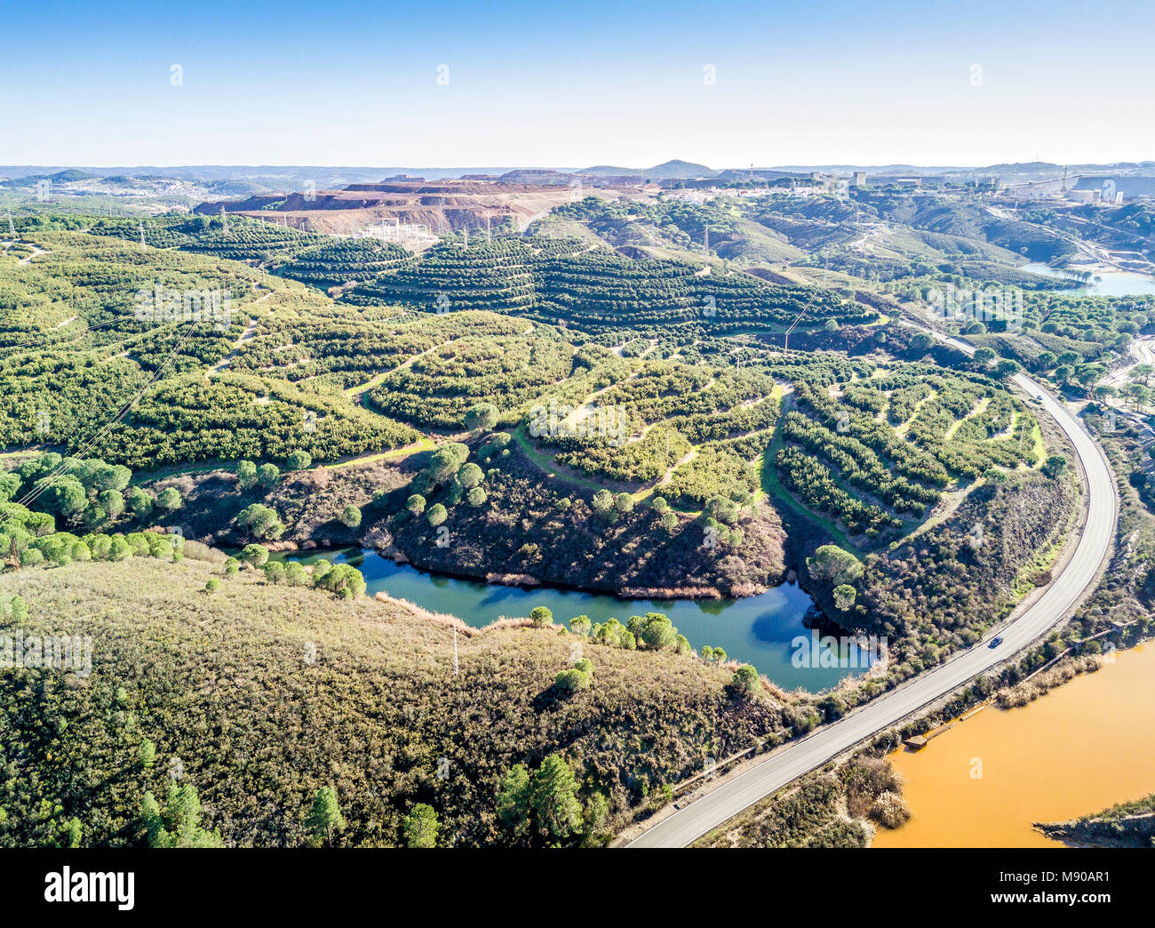 Aerial view of orange tree groves on hills and colorful lakes in Minas ...