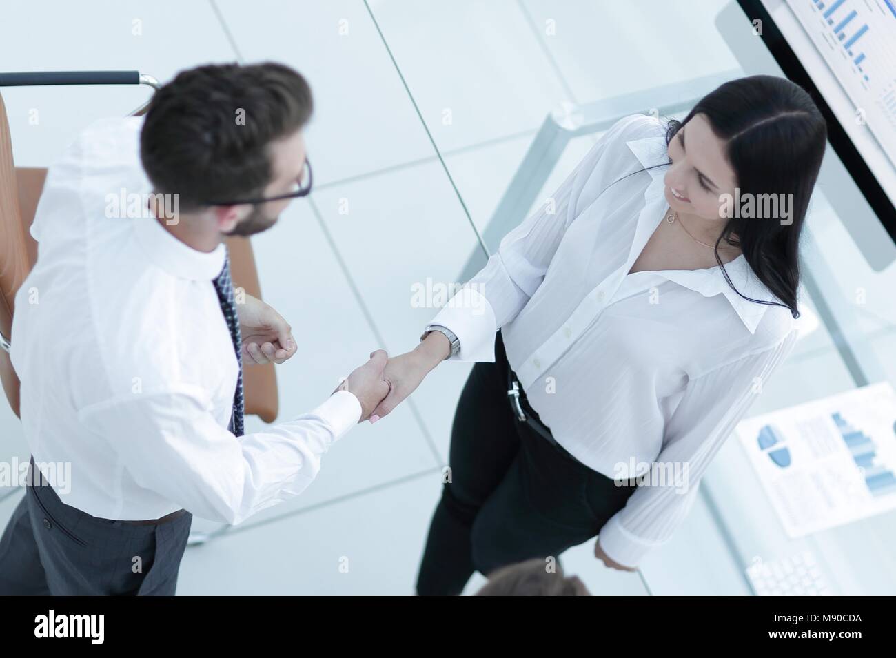 handshake manager and employee near the workplace. photo with copy ...