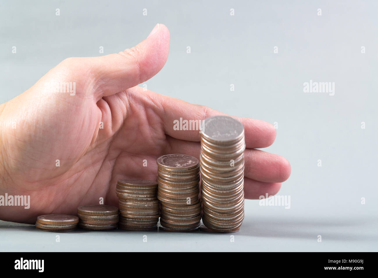Hand pushing a pile of coins, column of coins falls , business crisis ...
