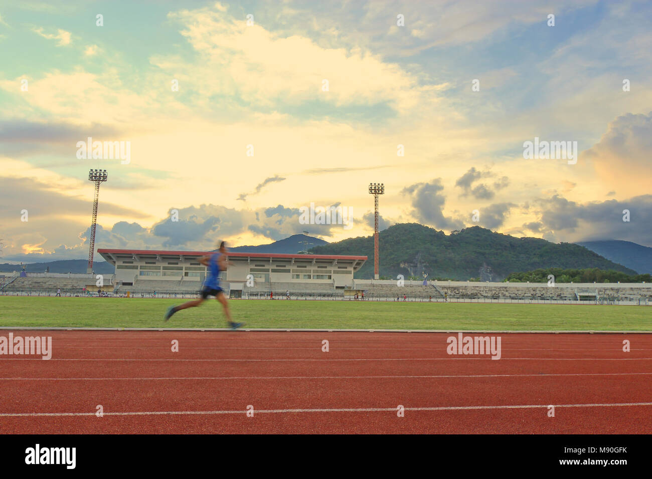 running in the stadium, mountain and blue sky background Stock Photo ...