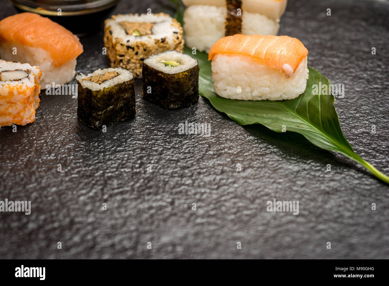 Traditional japanese sushi rolls hosomaki,uramaki, nigiri on stone desk ...