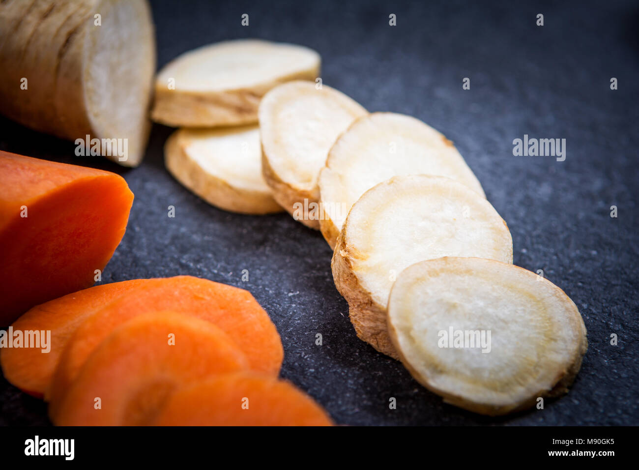 Cuts of parsley and carrot on dark stone table Stock Photo - Alamy
