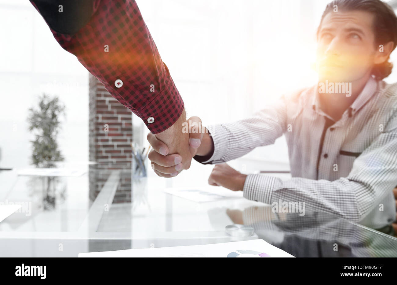 colleagues shaking hands over Desk Stock Photo - Alamy