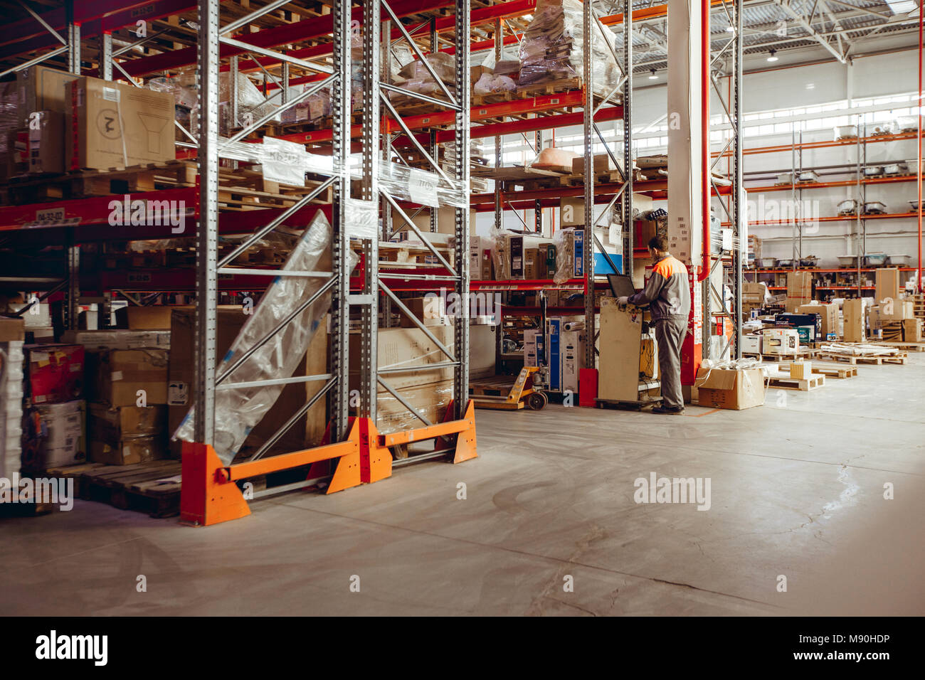 Warehouse full of goods with man in the background Stock Photo - Alamy