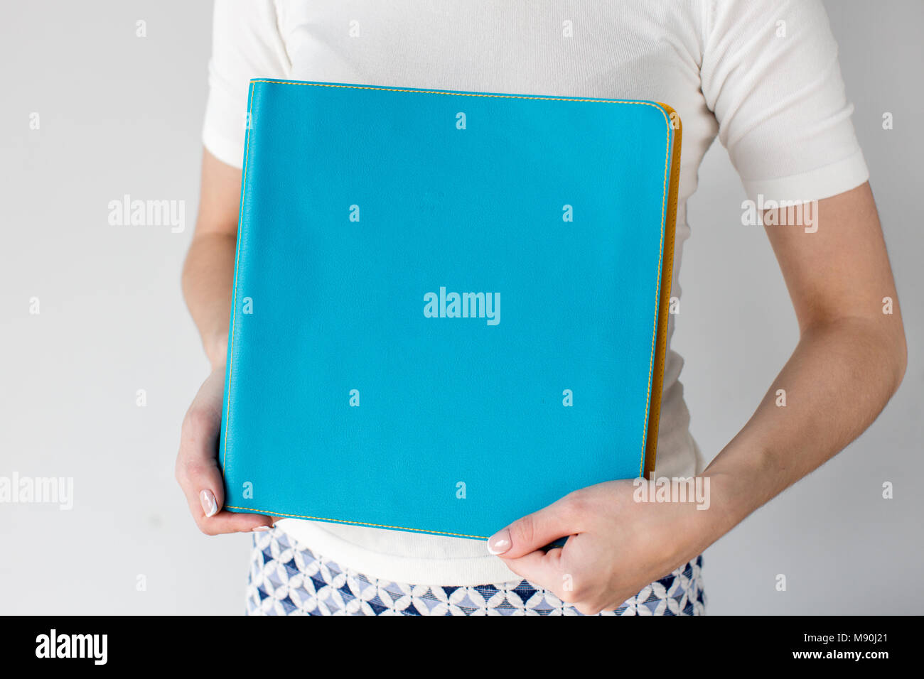 Female holding blue paper folder Stock Photo - Alamy
