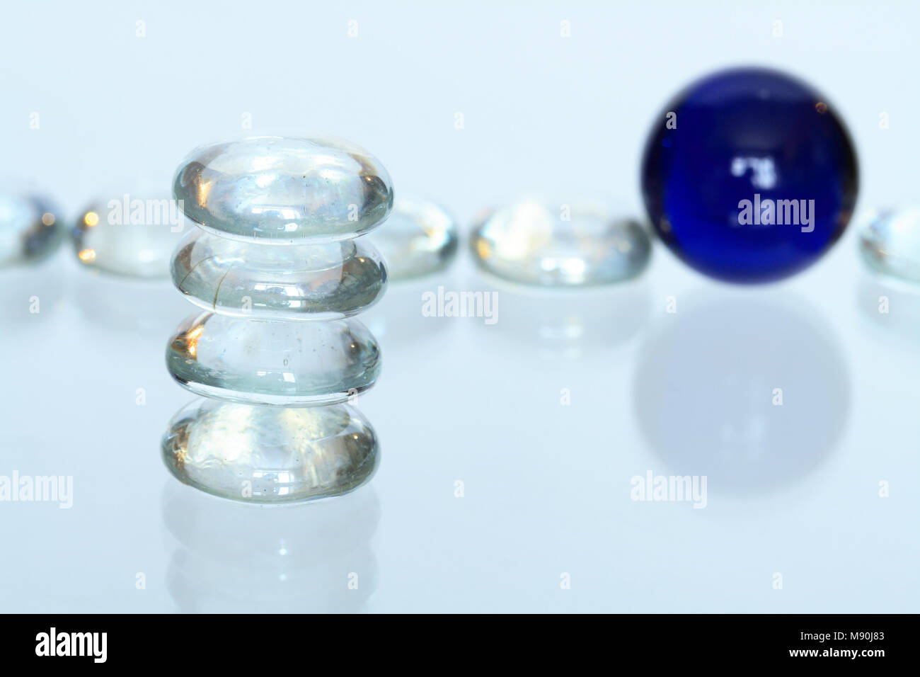 Stack of four glass stones on backround with glass balls lying in a row ...