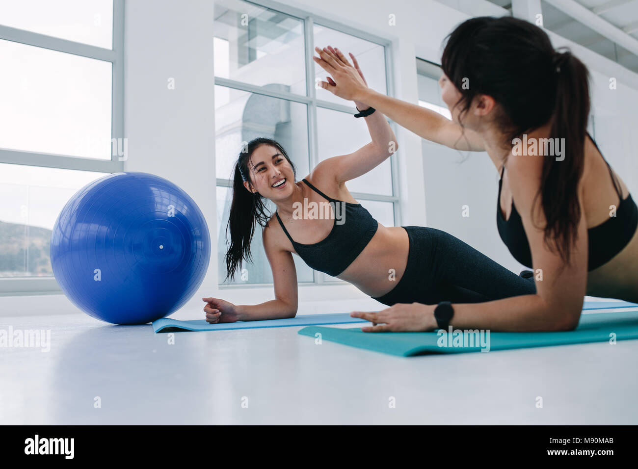 Sporty women giving high five to each other while working out together ...