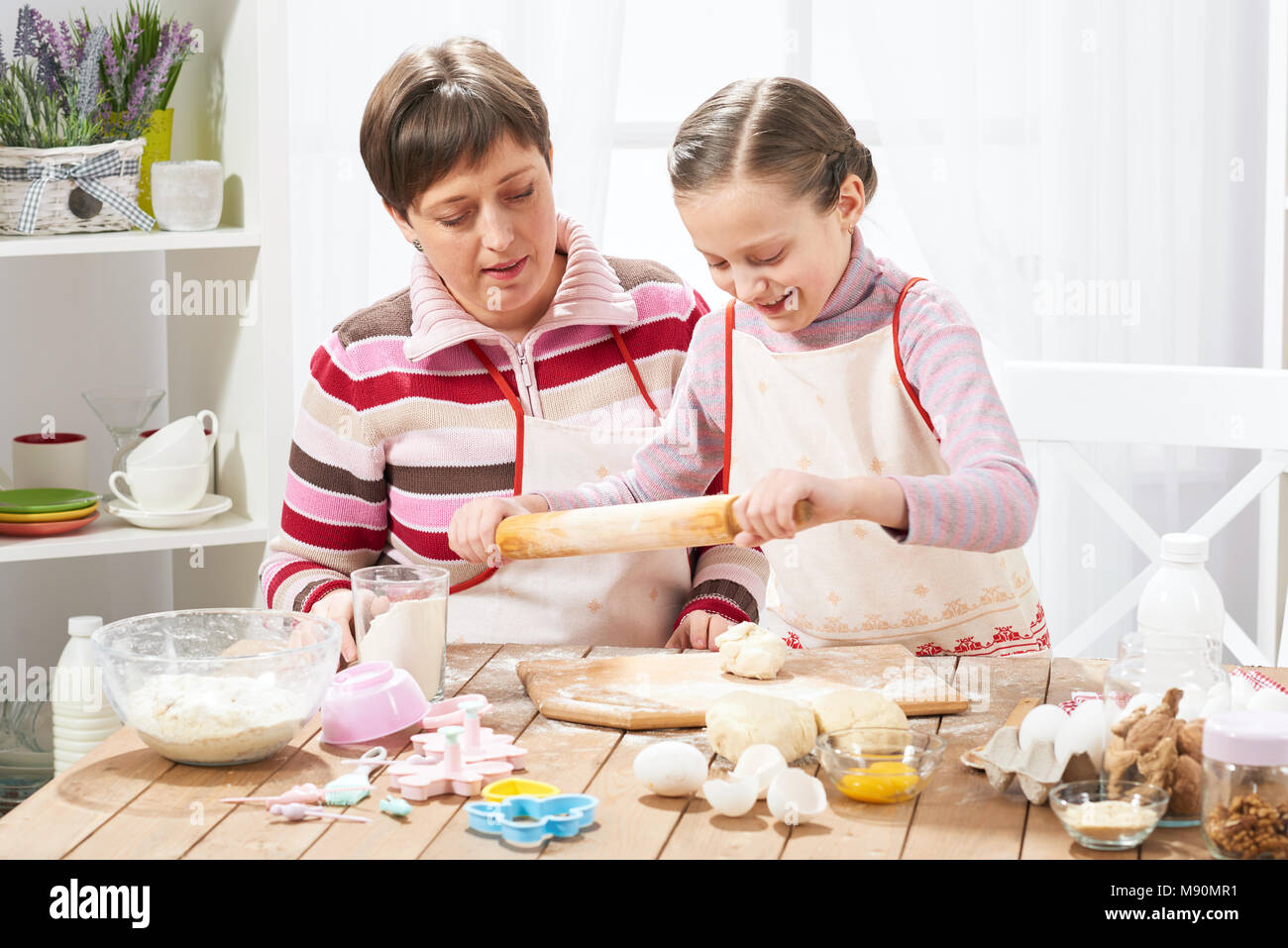 Mother and daughter cooking at home, making the dough for buns Stock ...