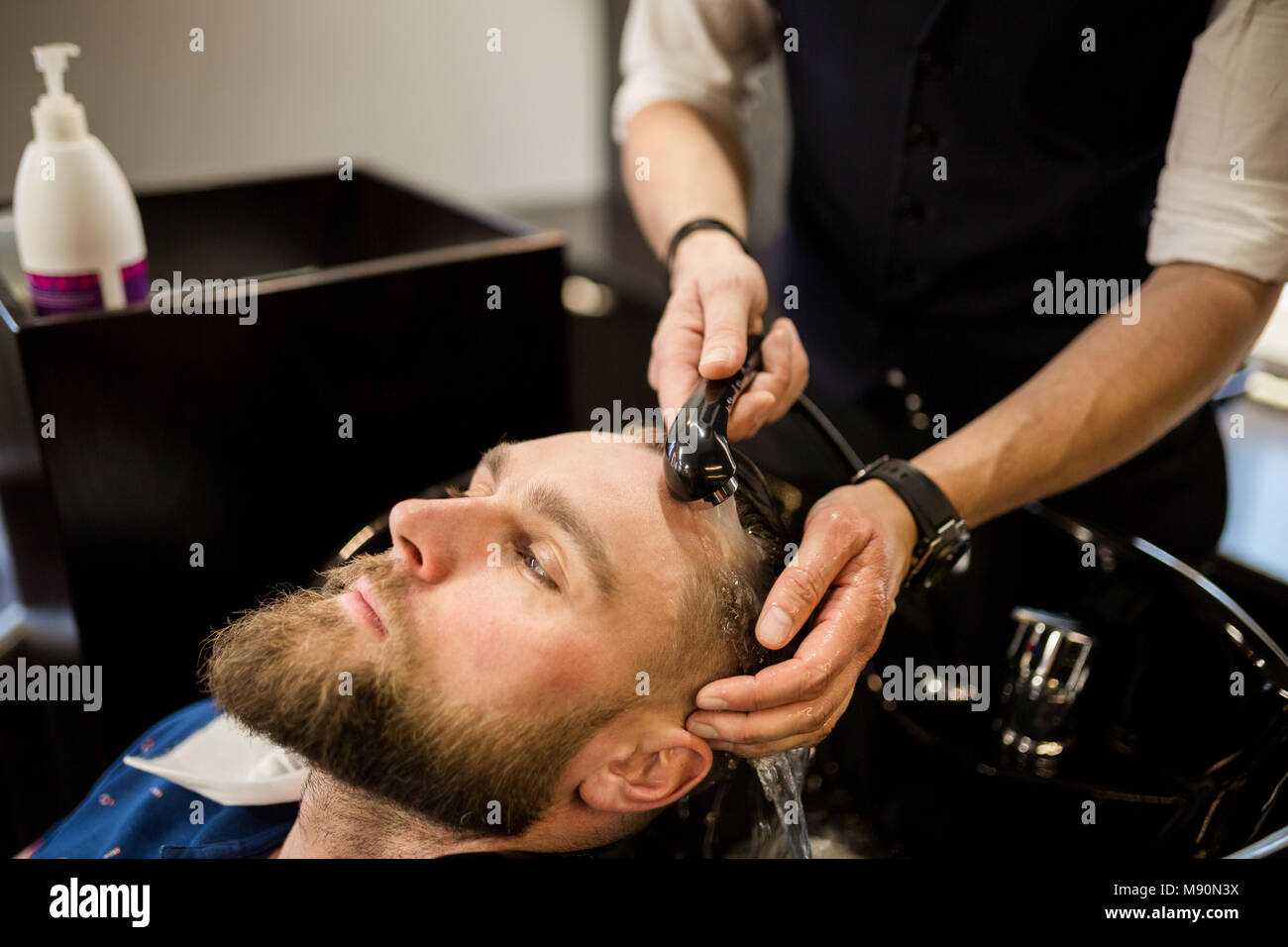 Barber washing hair client hi-res stock photography and images - Alamy