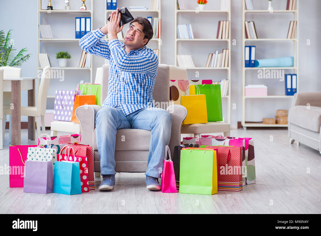 Young man after excessive shopping at home Stock Photo - Alamy