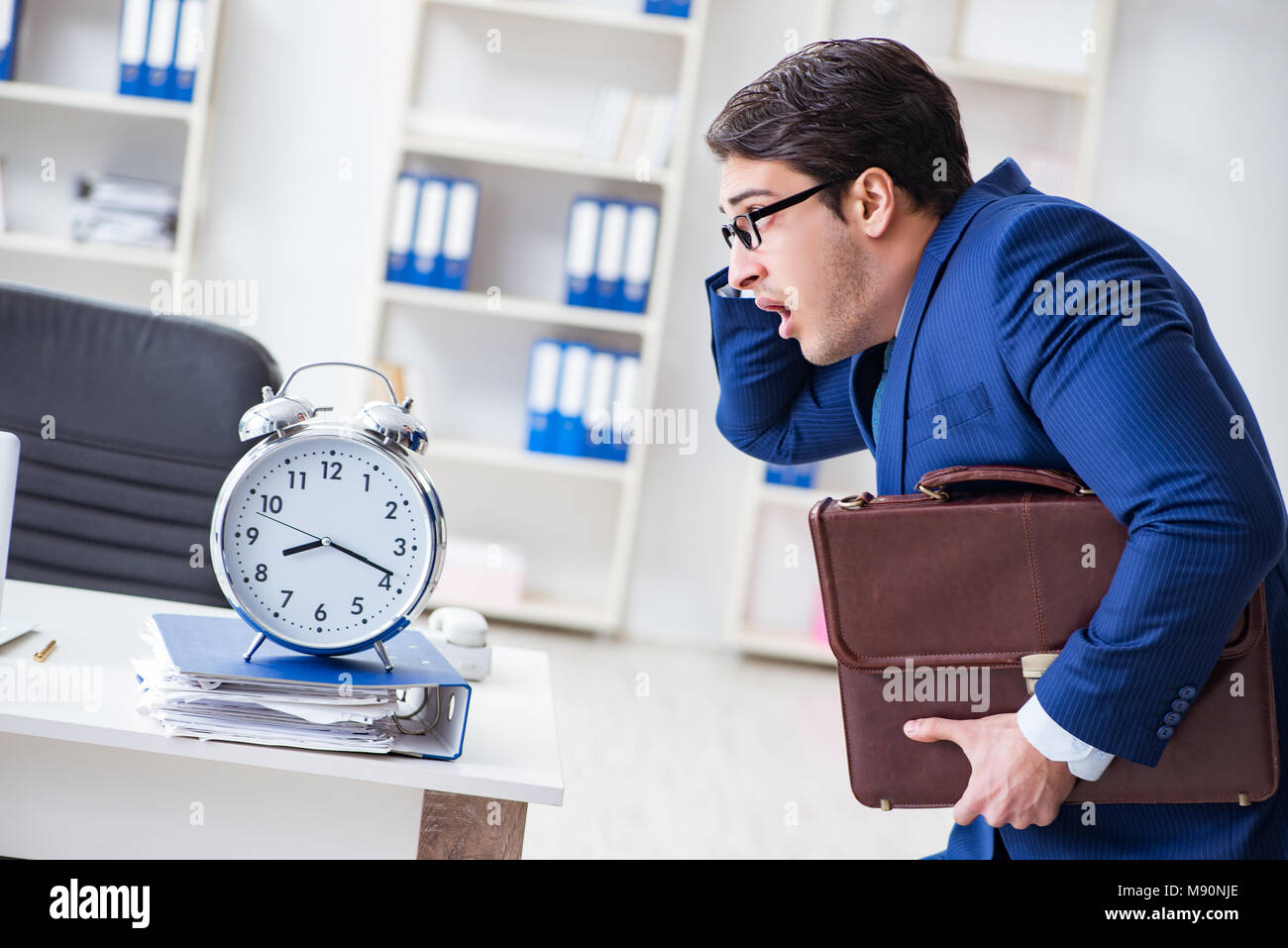 Businessman in bad time management concept Stock Photo - Alamy