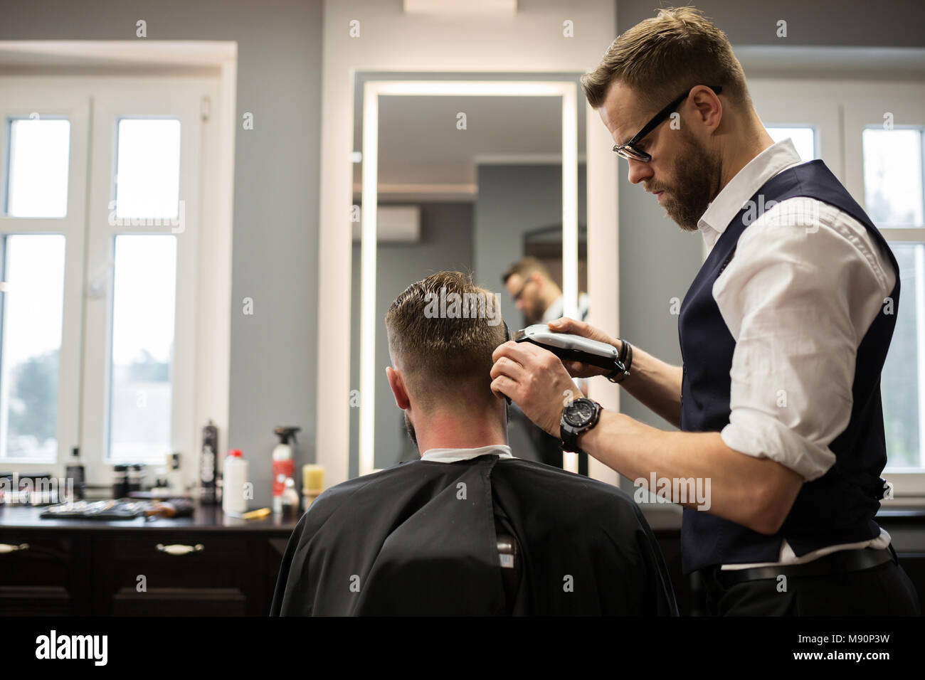 Portrait of focused barber having customer hair Stock Photo - Alamy