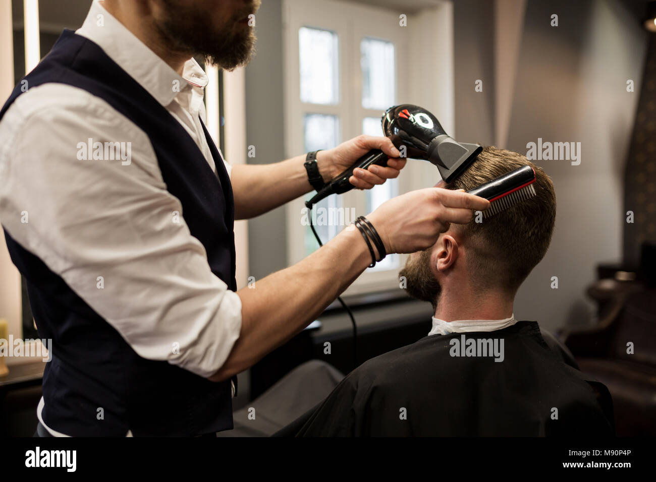 Cropped portrait of barber styling customer hair with drier Stock Photo ...