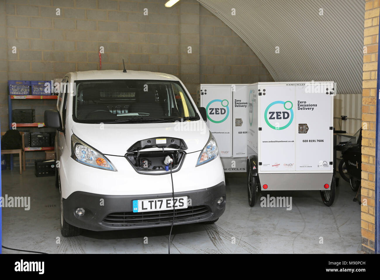 A Nissan eNV200 electric van plugged in for recharging in a garage in ...