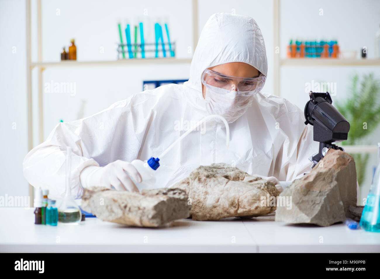 Scientist looking and stone samples in lab Stock Photo - Alamy