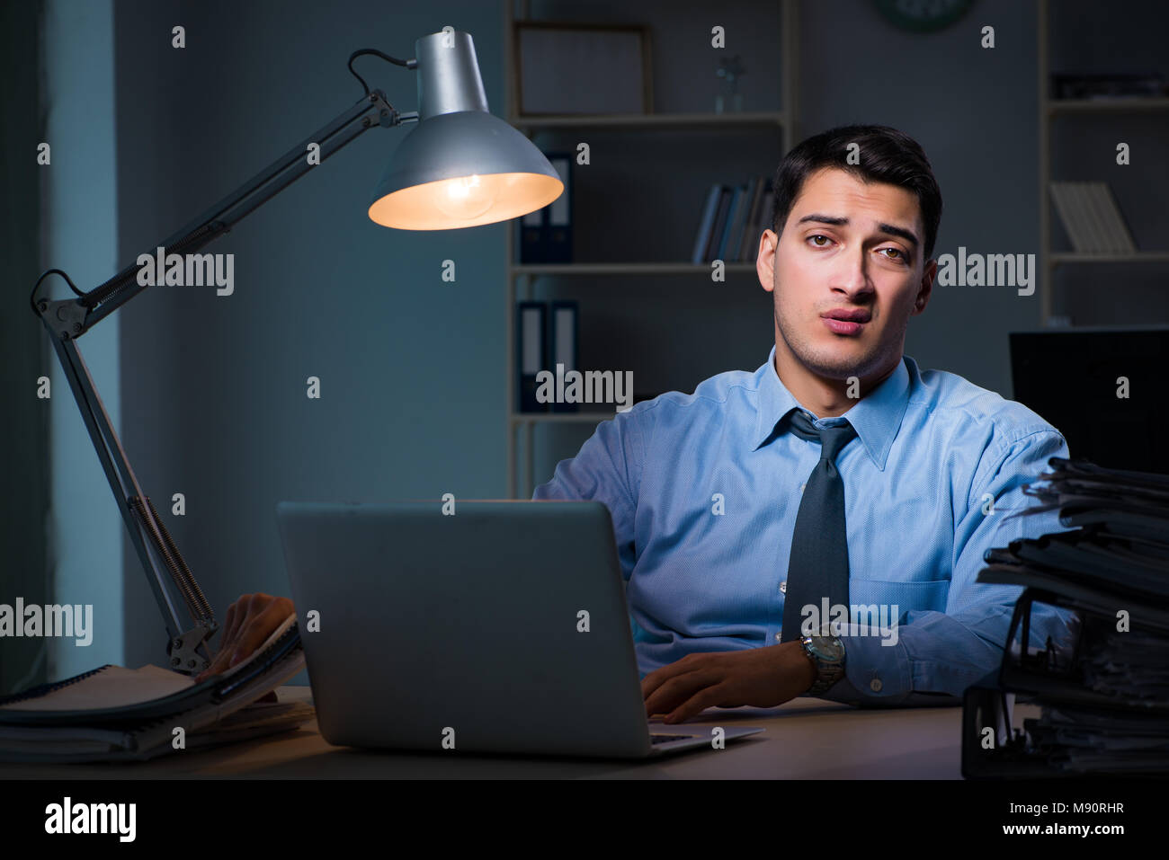 Employee working late at night at important report Stock Photo - Alamy