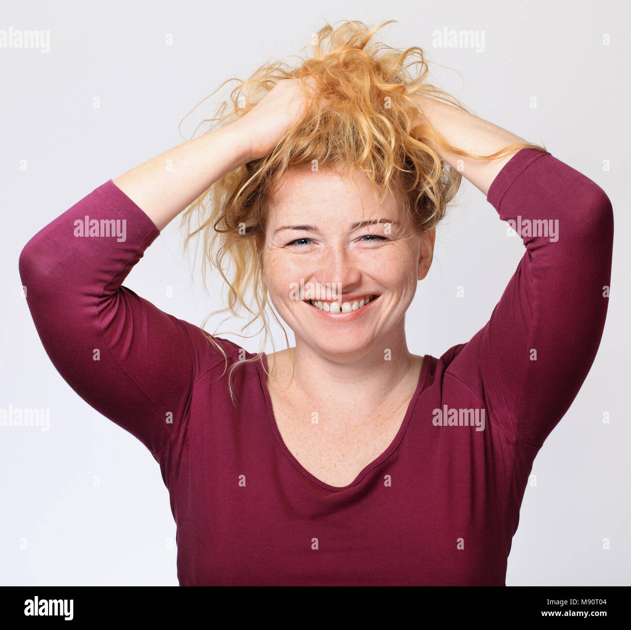 Young smiling woman pointing her hair Stock Photo - Alamy