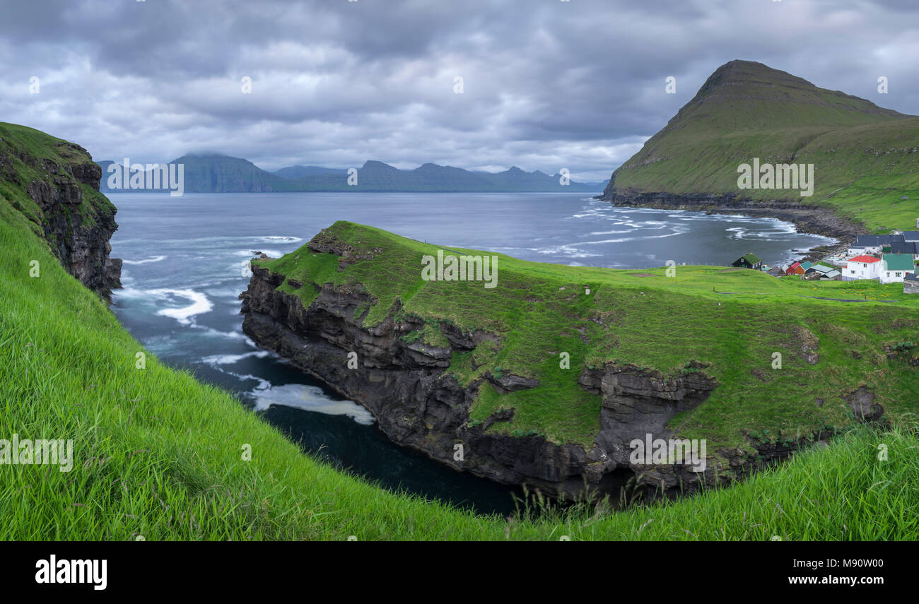 Cliff top view over the gorge at Gjogv towards the island of Kalsoy ...