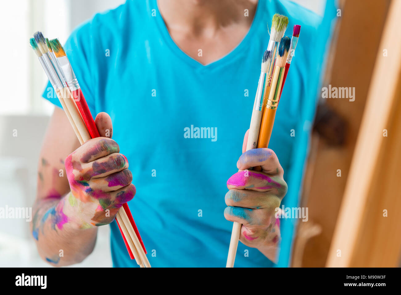 Young funny artist working on new painting in his studio Stock Photo ...