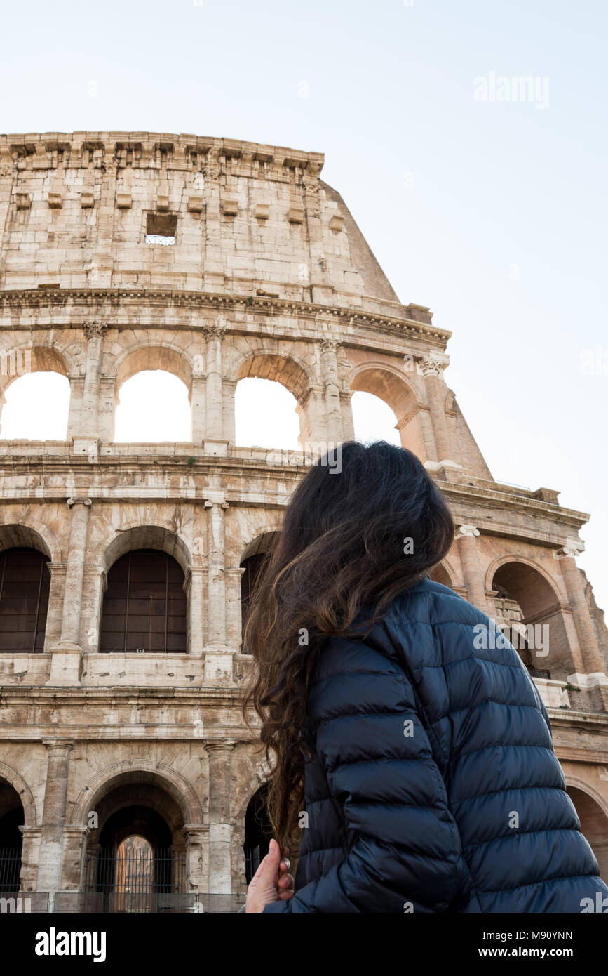 Vertical picture of the back of long hair woman looking at Colosseo in ...