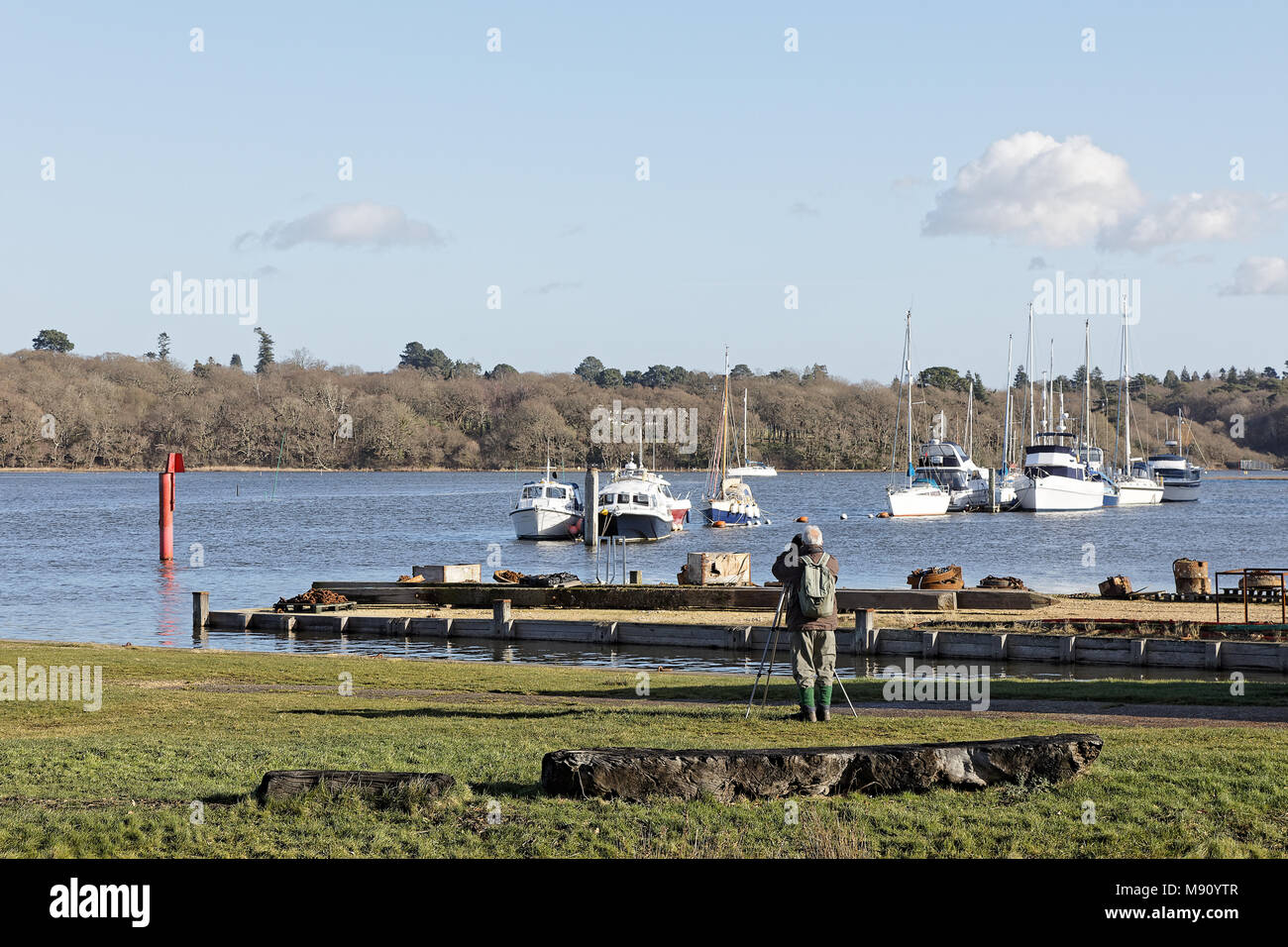 A bird watcher using binoculars in the River Beaulieu estuary Stock ...