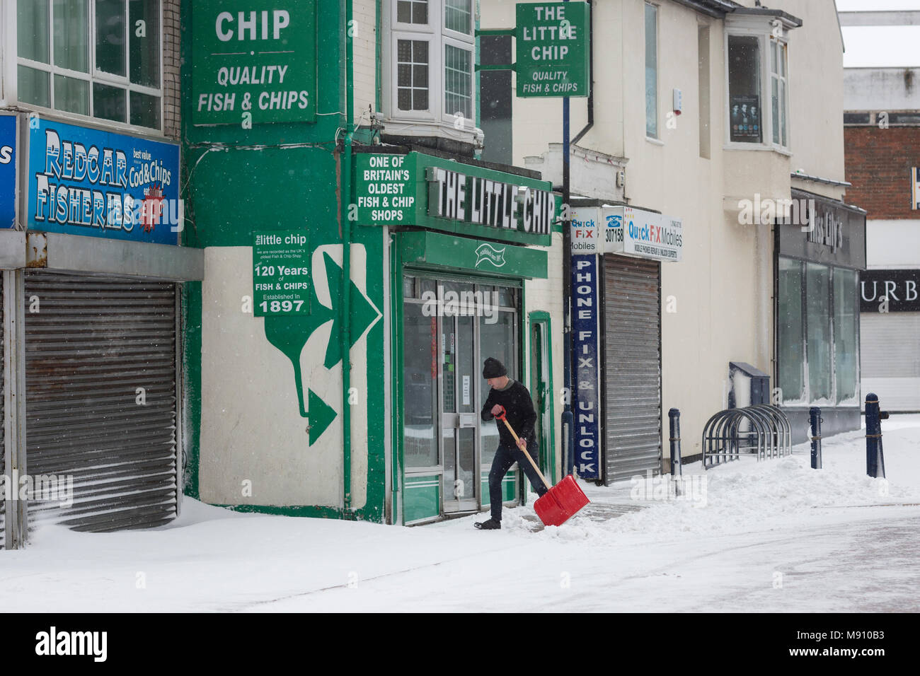 Redcar , North Yorkshire , England.A man clears snow from in front of ...