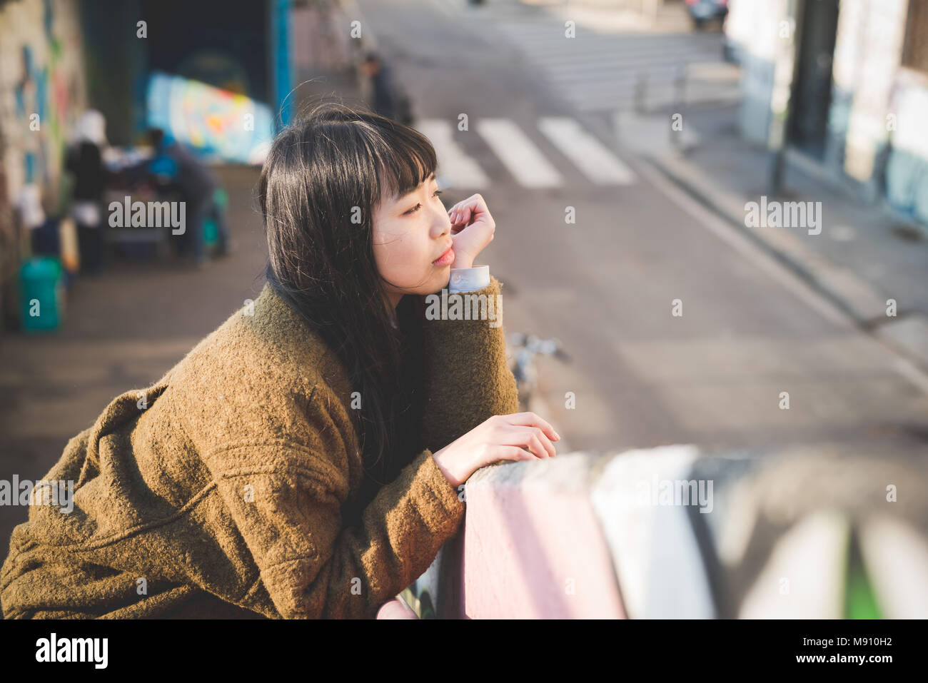 young woman looking away back light outdoor city serious - pensive ...