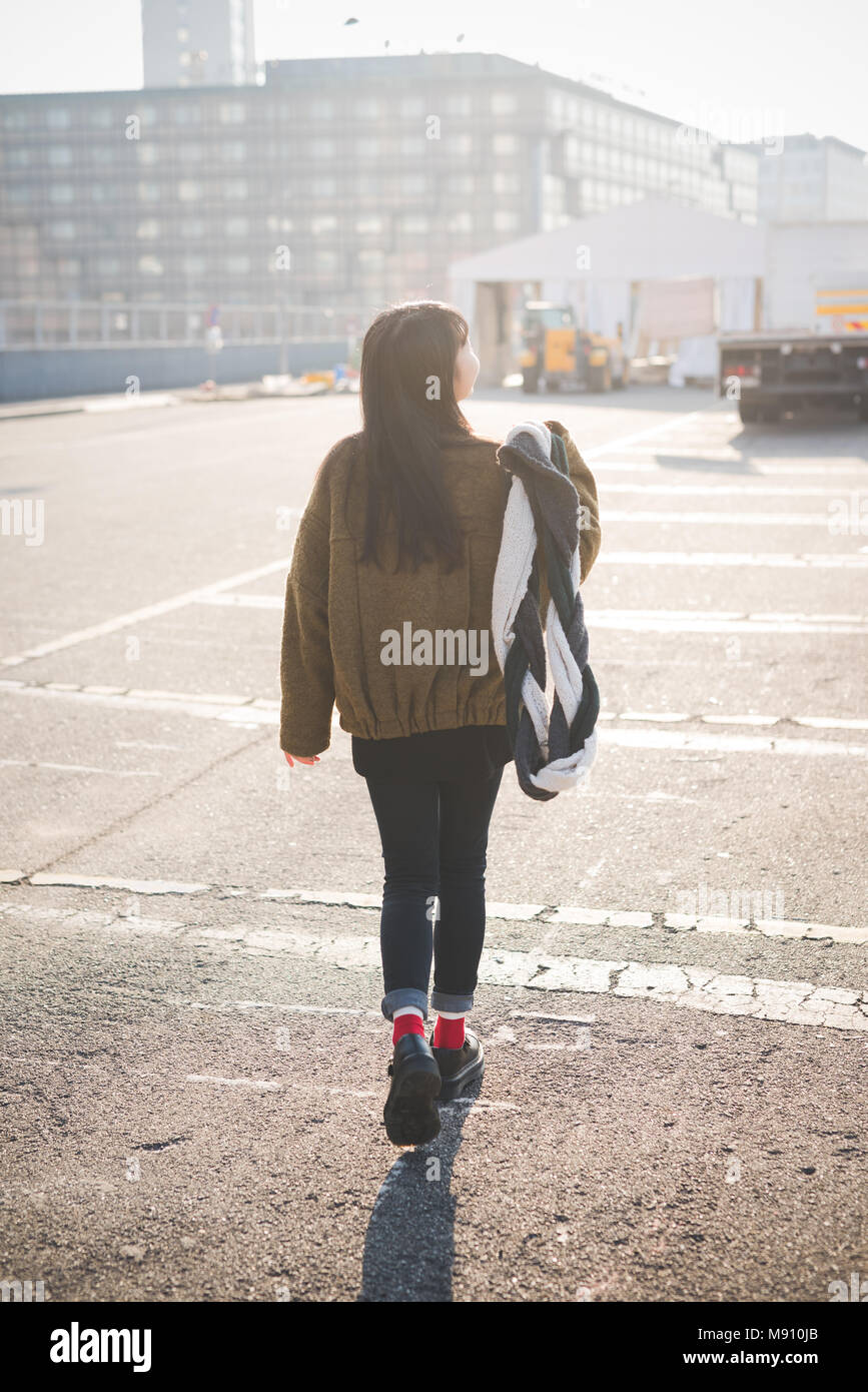back view young woman looking away back light walking outdoor city ...