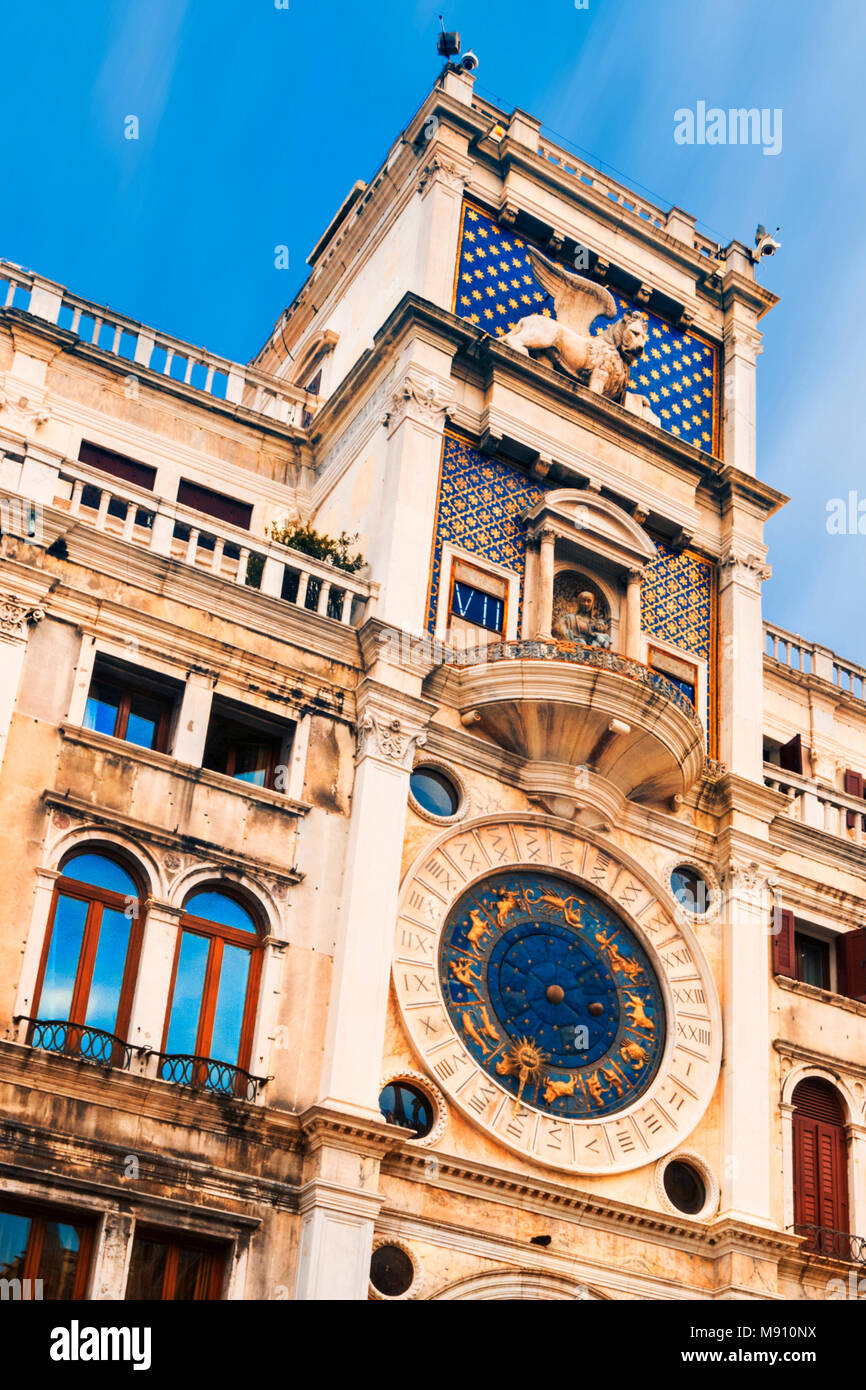 Blue and gold clock face with symbols of zodiac and virgin mary on ...