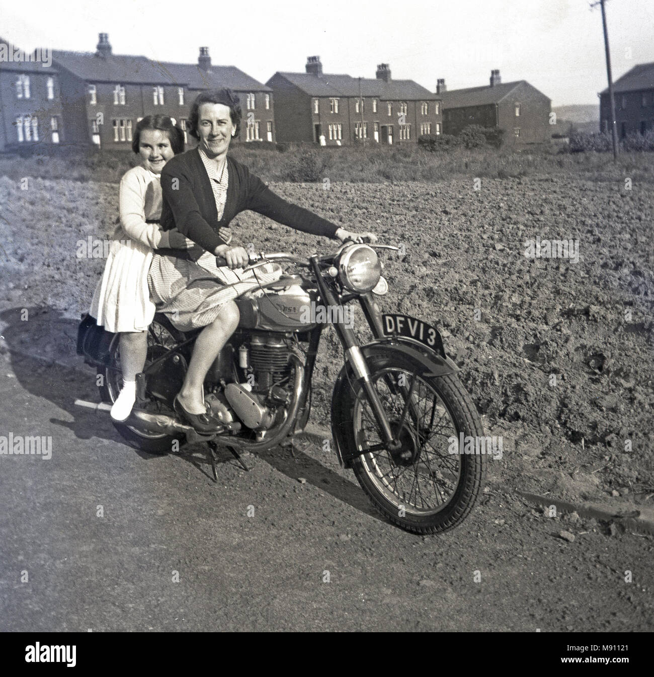 1950s, historical, outside some rural cottages, by a ploughed field, a ...