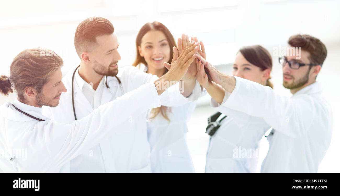 group of doctors giving each other a high five Stock Photo - Alamy