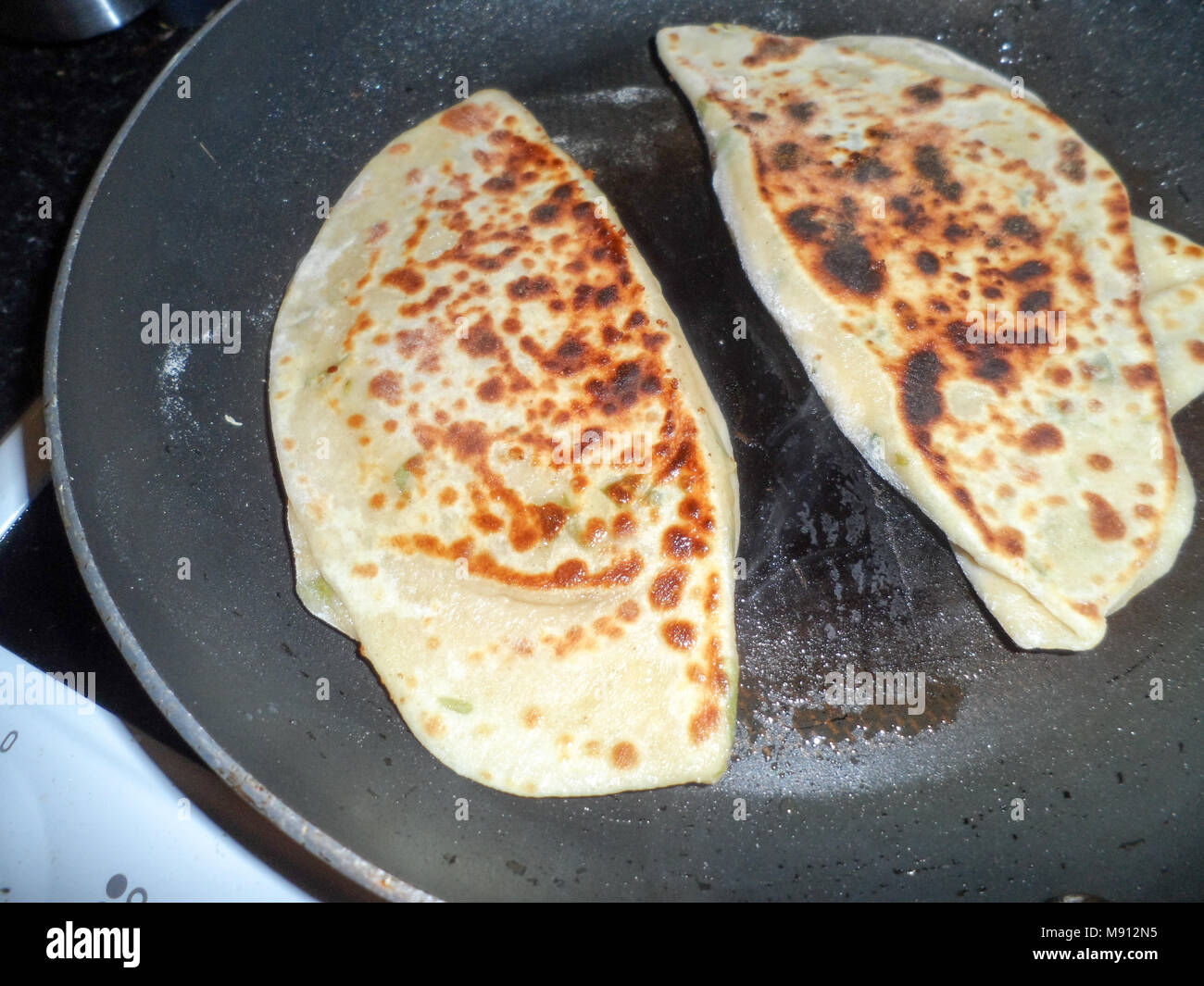 Traditional Cheese and herb Azerbaijani pie cooking in a skillet Stock ...