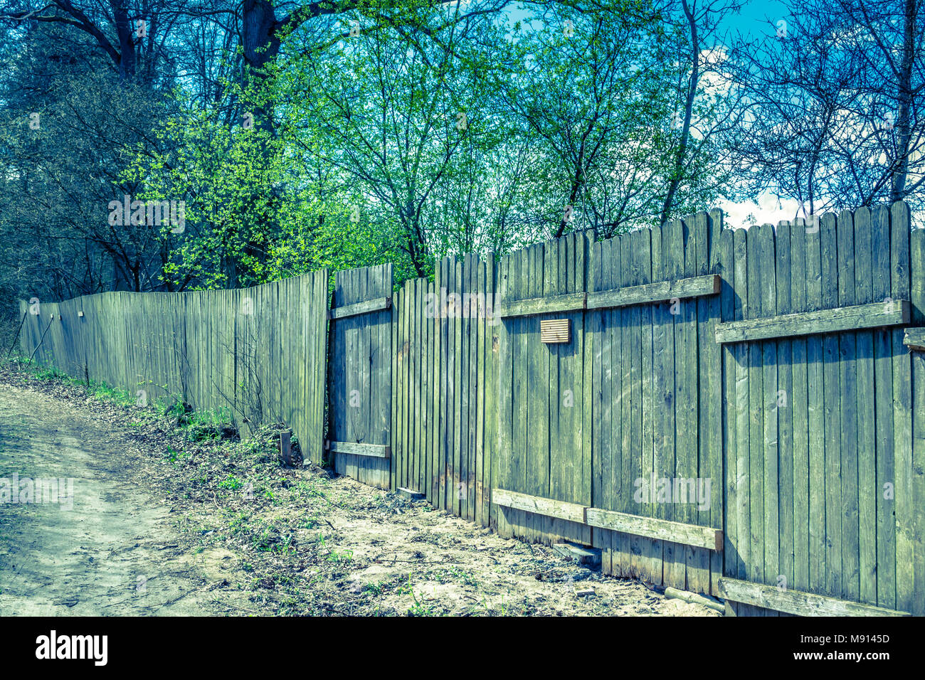Rural road and wooden fence, spring landscape with countryside scene ...