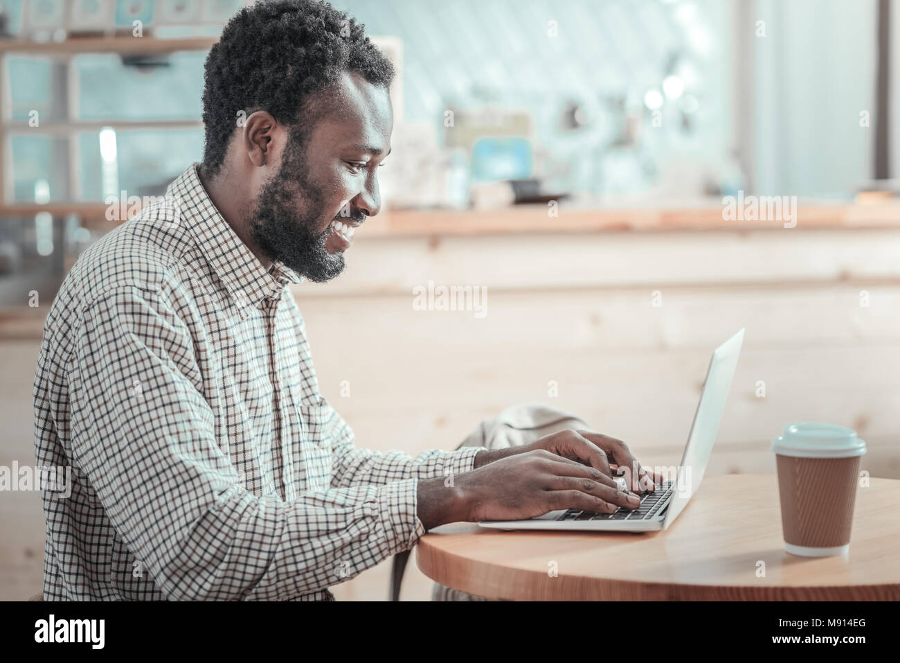 Happy positive man typing Stock Photo - Alamy