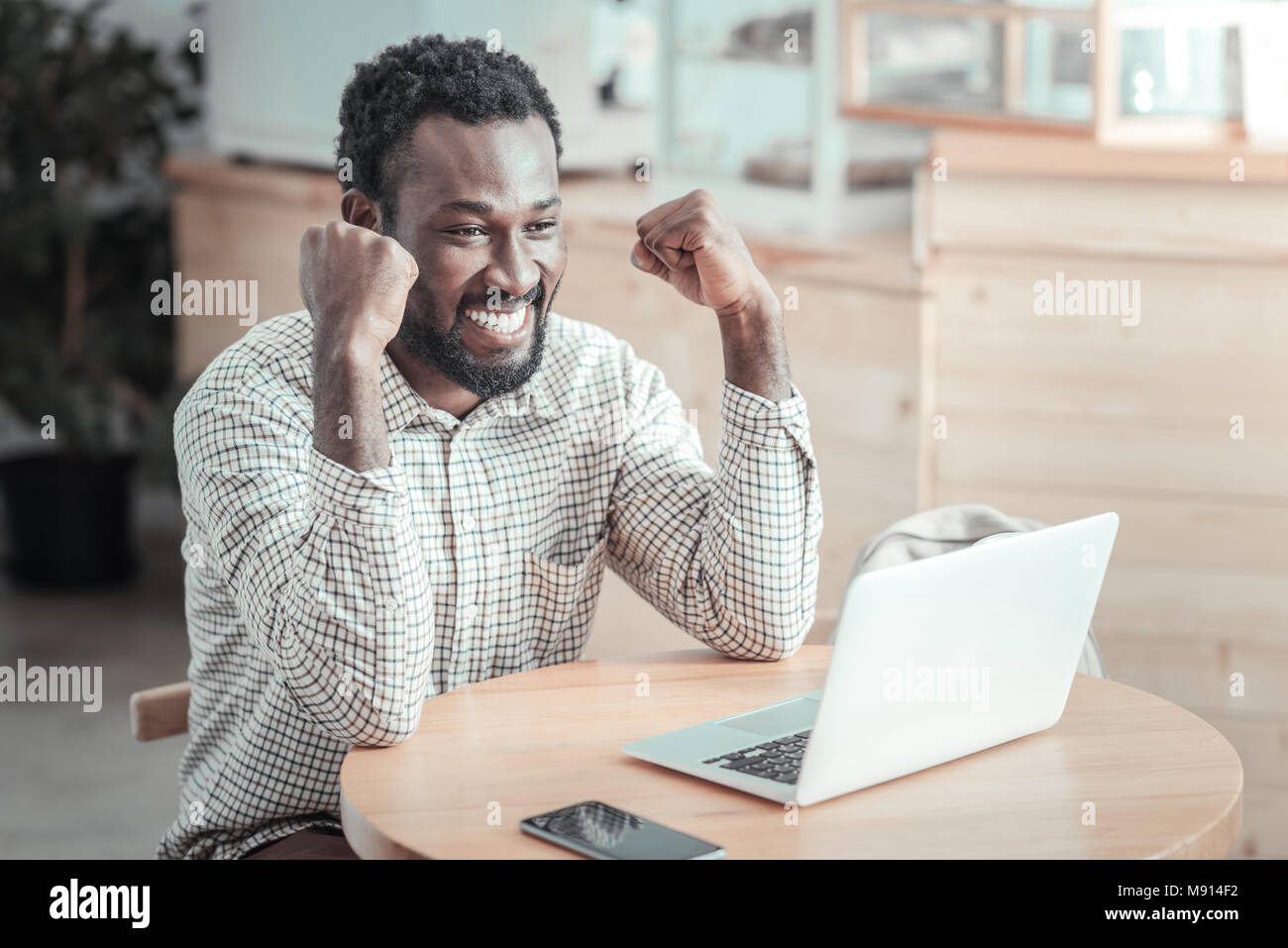 Happy cheerful man looking at the netbook screen Stock Photo - Alamy