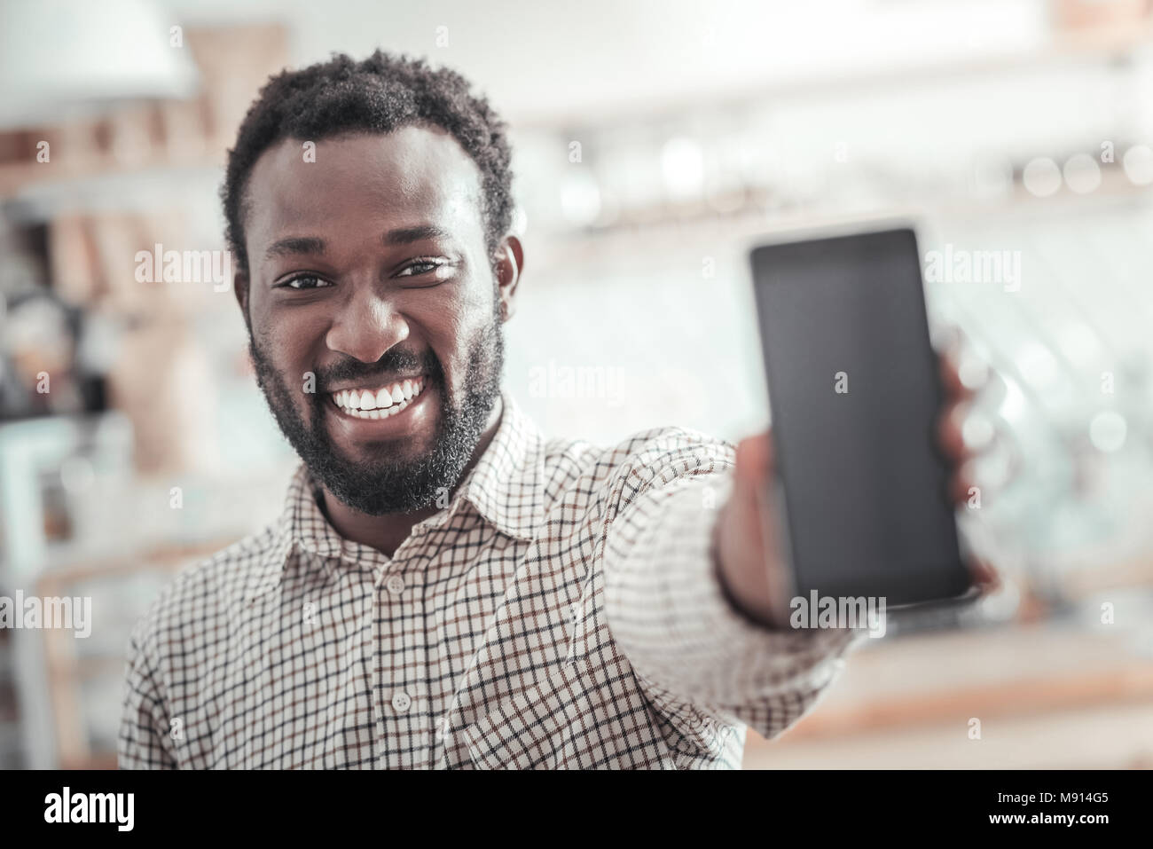 Happy positive man showing his smartphone Stock Photo - Alamy