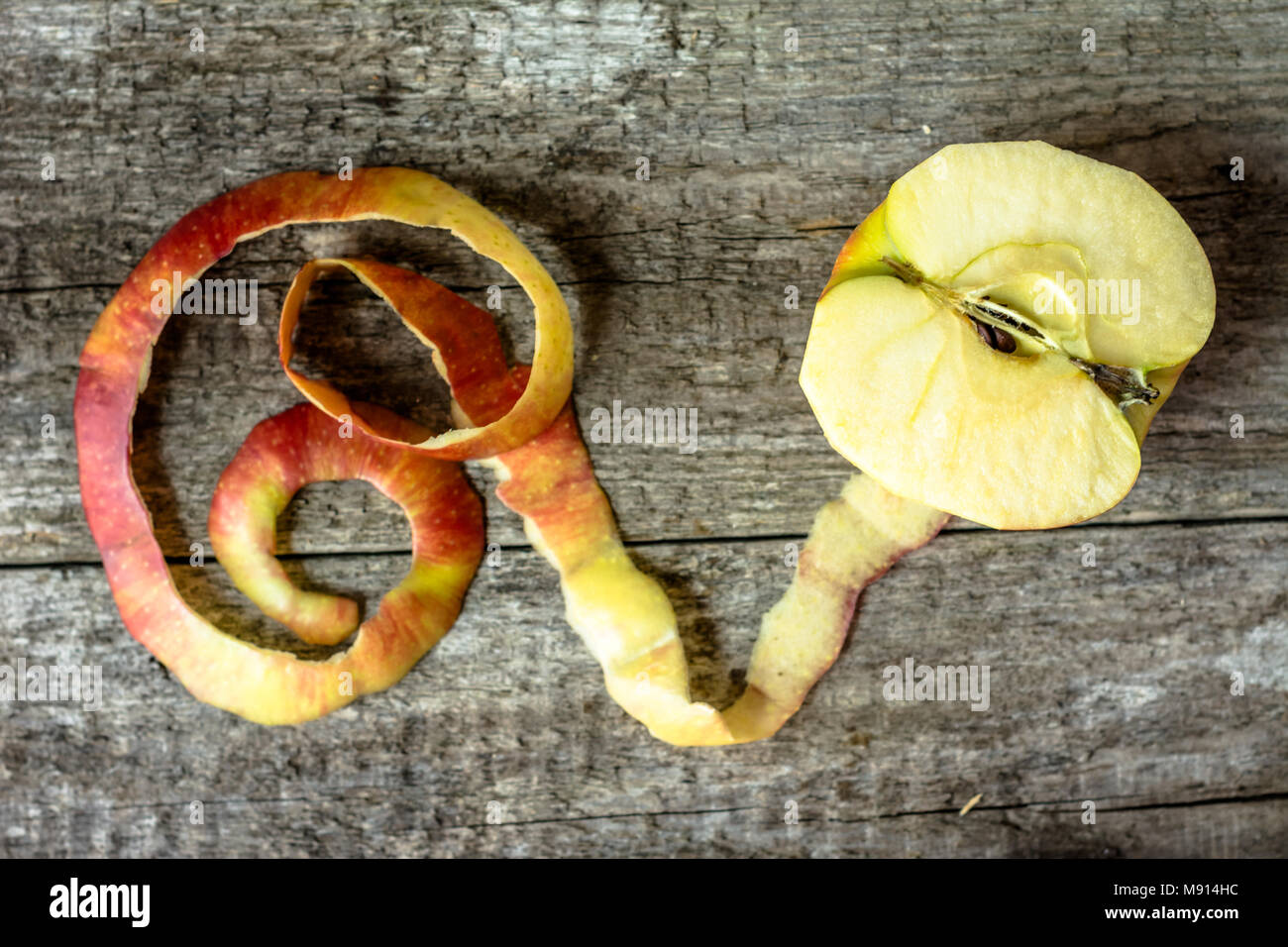Half of apple with peeled peel on wooden table, cross section, top view ...