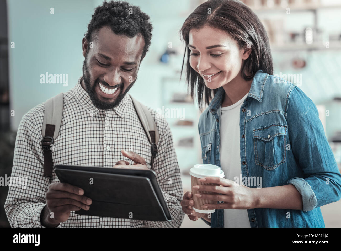 Delighted positive people looking at the tablet screen Stock Photo - Alamy