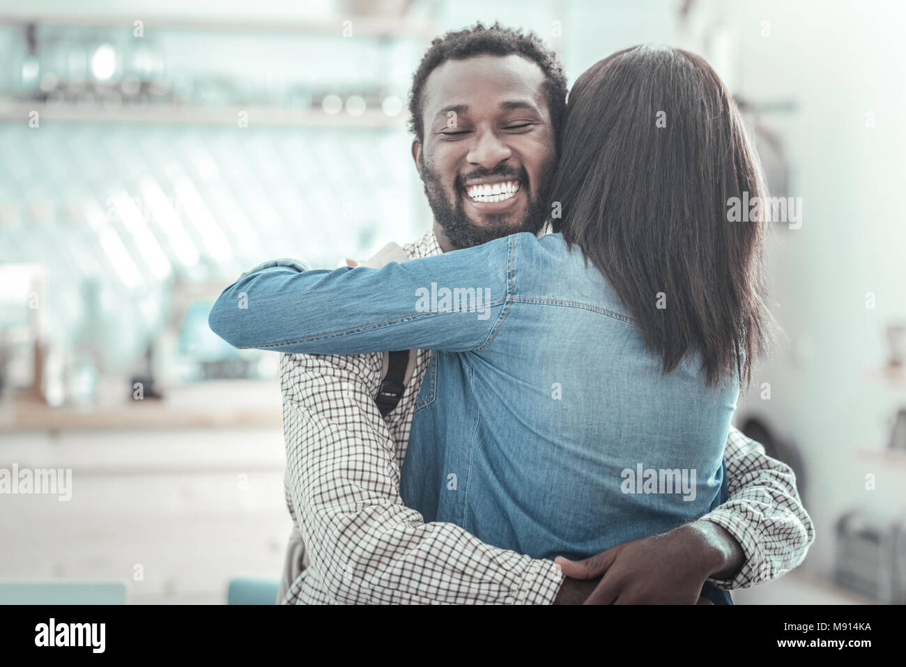 Joyful positive man hugging his friend Stock Photo - Alamy