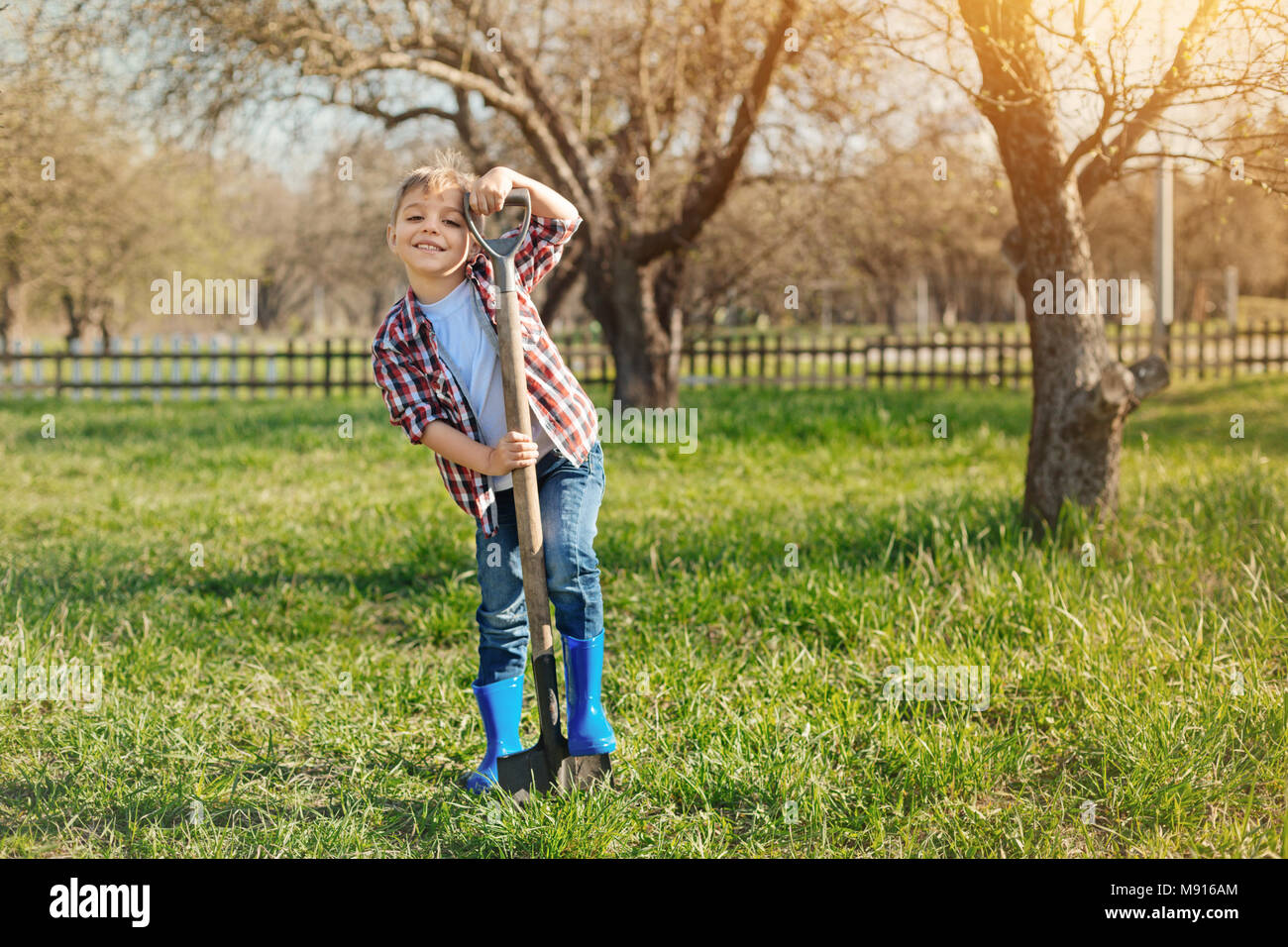 Positive little boy going to dig the soil Stock Photo - Alamy