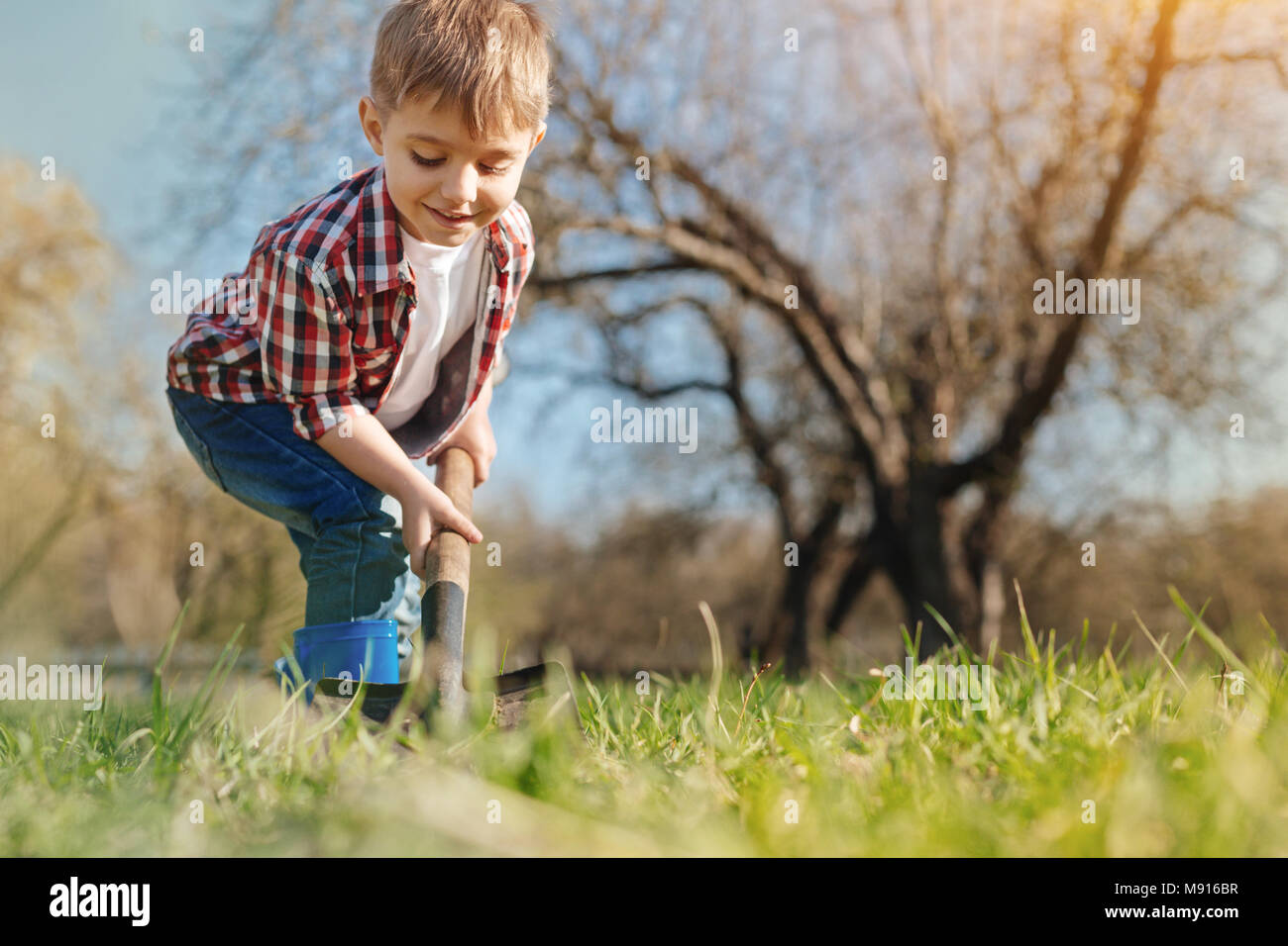 Enthusiastic little boy digging the ground in the garden Stock Photo ...