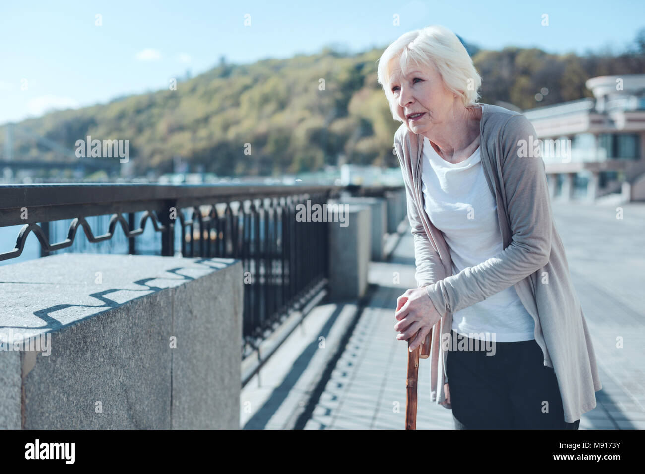 Ill elderly lady promenading along the riverwalk Stock Photo - Alamy