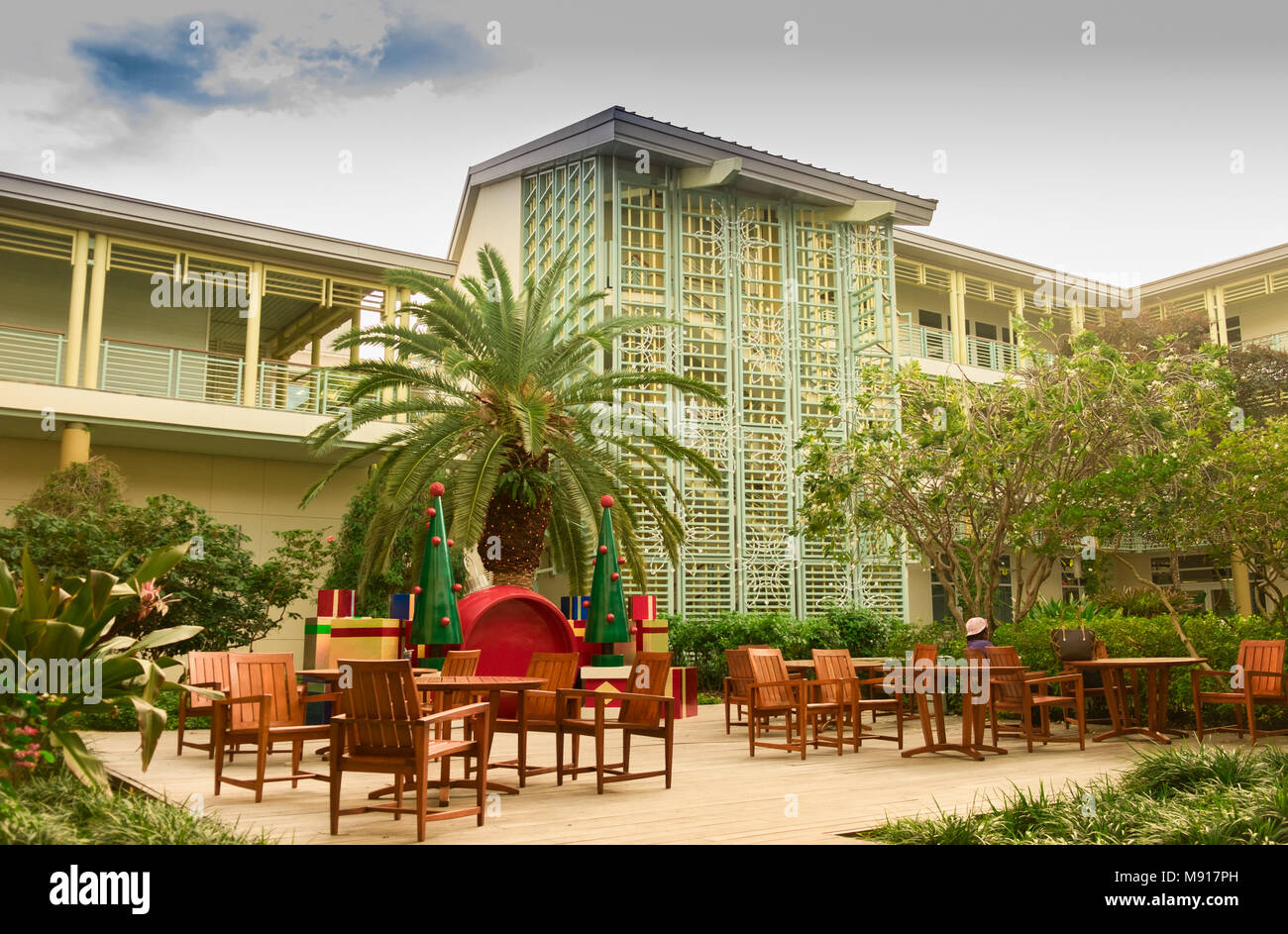 Grand Cayman, Cayman Islands, woman sitting at a Camana Bay terrace ...
