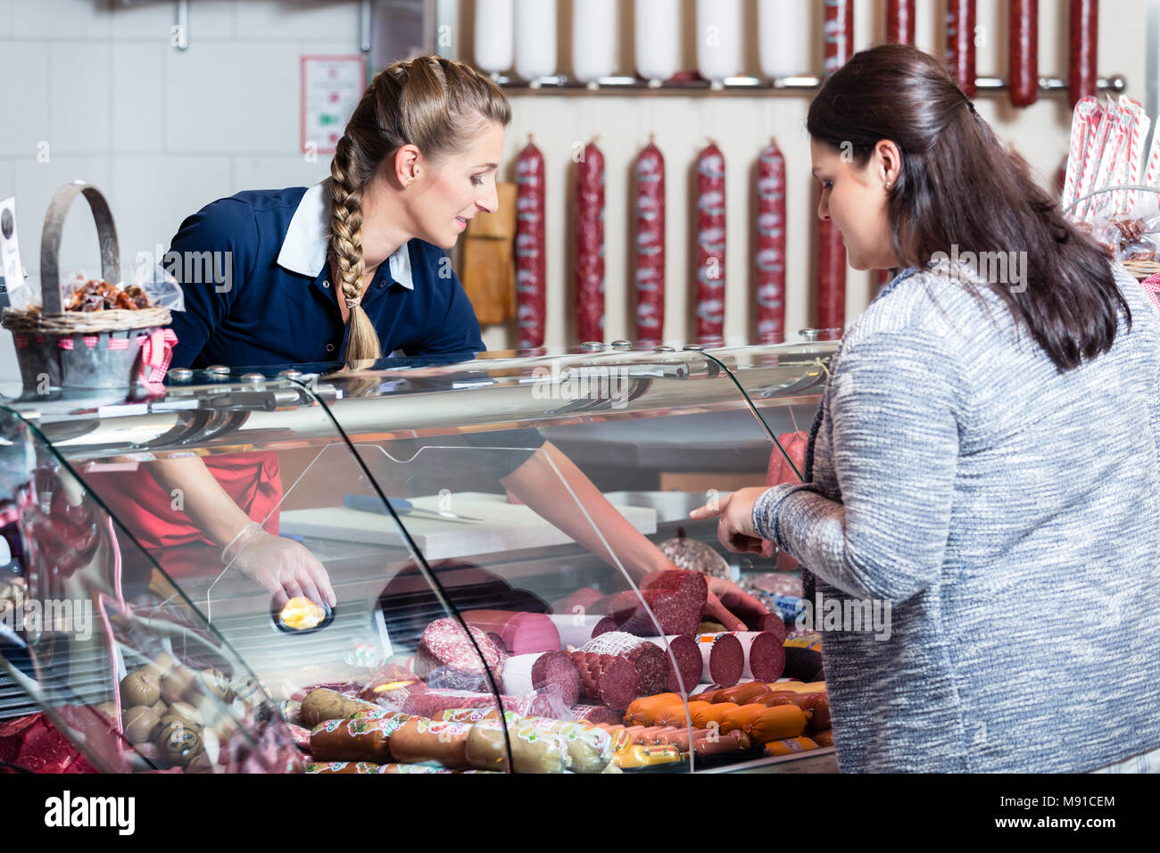 Sales lady in butchery shop serving customer Stock Photo - Alamy