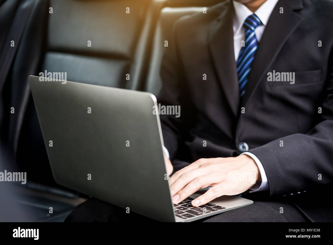 Handsome Young businessman using laptop and sitting in back seat of car Stock Photo - Alamy