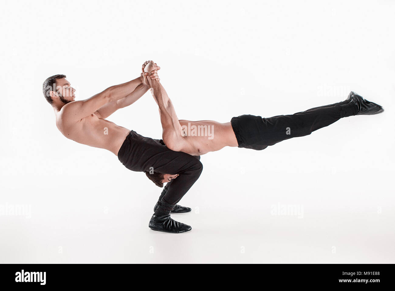 The group of gymnastic acrobatic caucasian men on balance pose Stock ...